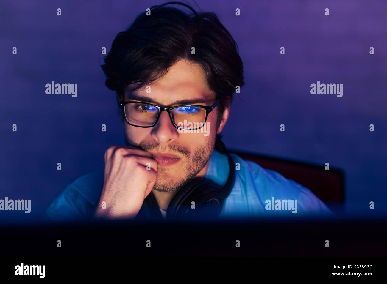 Young Man Wearing Glasses Works On Computer in Dark Room Stock Photo ...