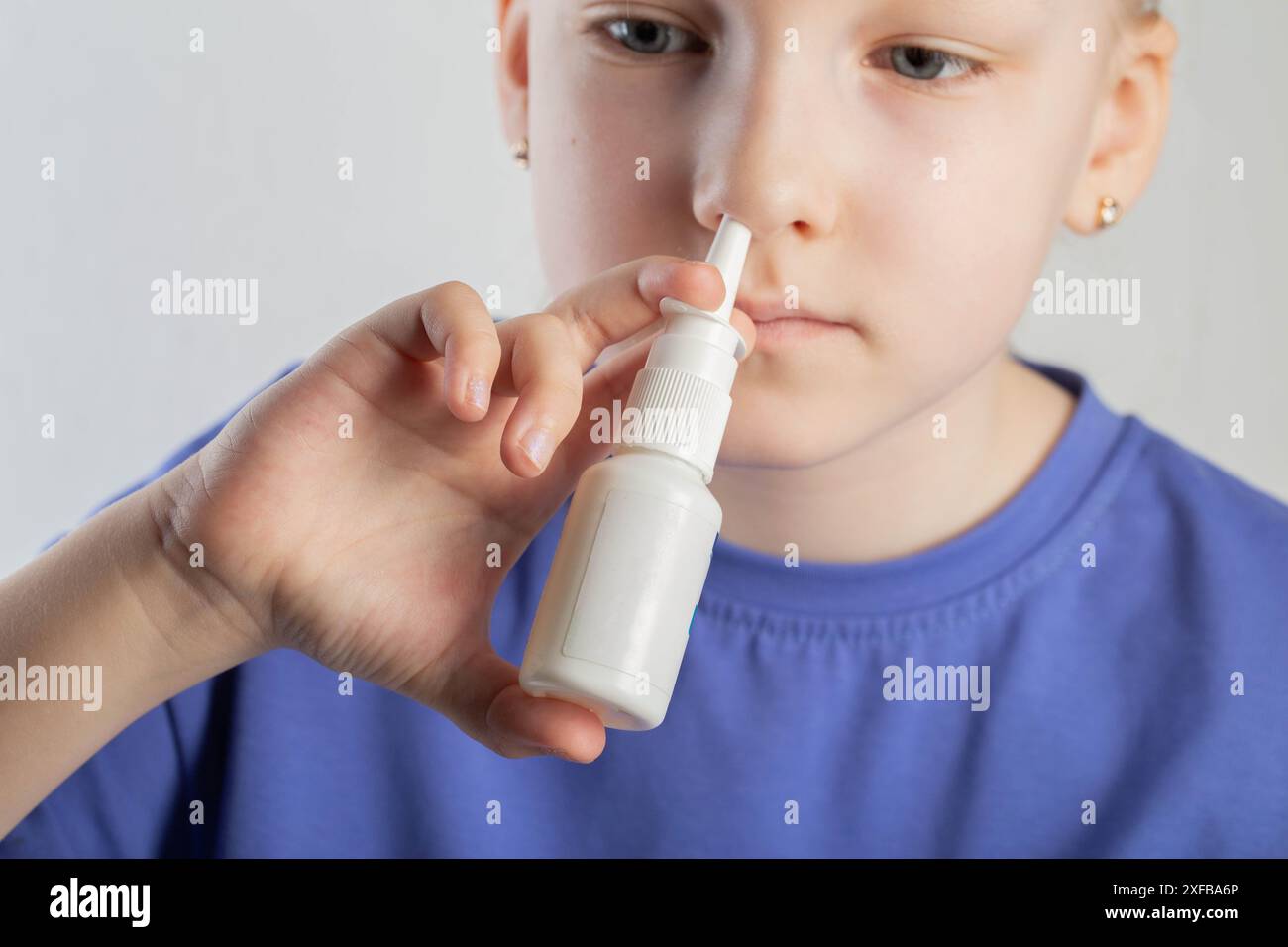 A caucasian girl puts drops into her nose and an anti-inflammatory ...