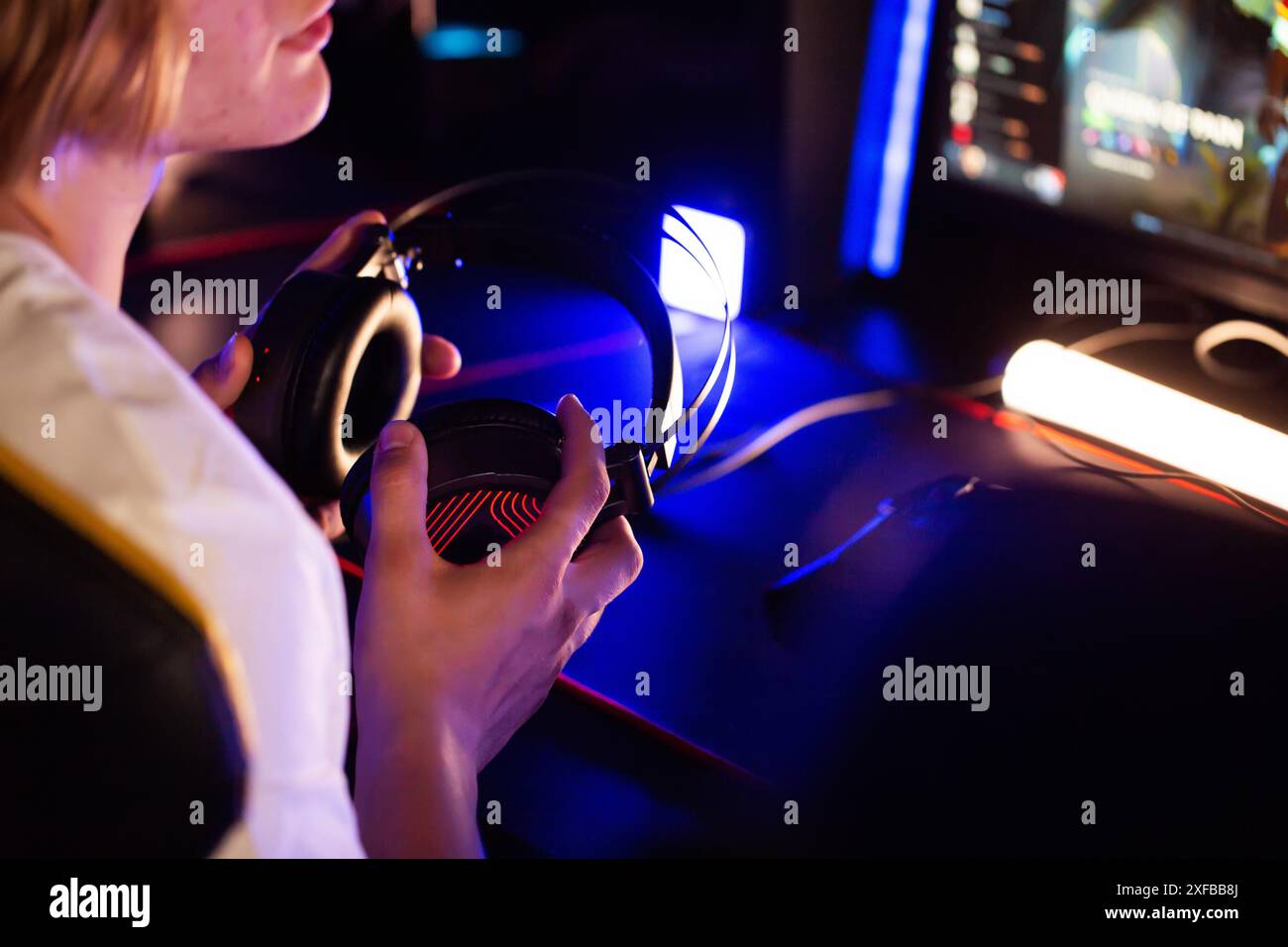 Pimply teen gamer puts on headset at PC computer club, cyber sport ...