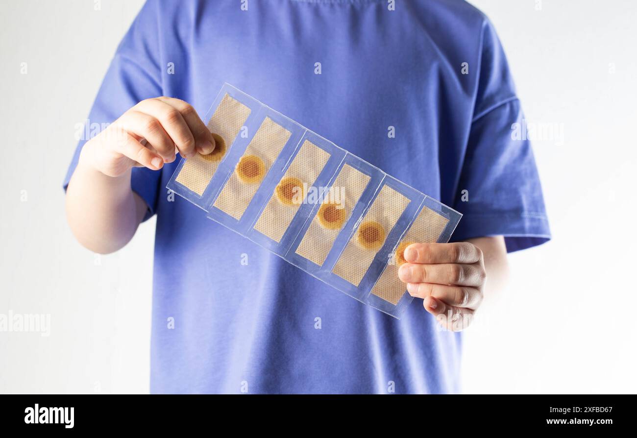 A child holds in his hands a package with an adhesive plaster for core ...