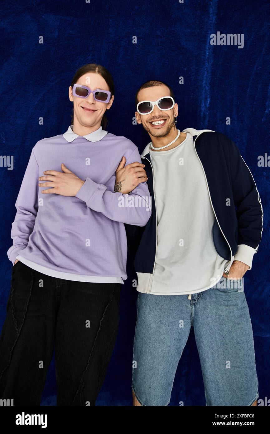 Two men posing in front of a blue background Stock Photo - Alamy