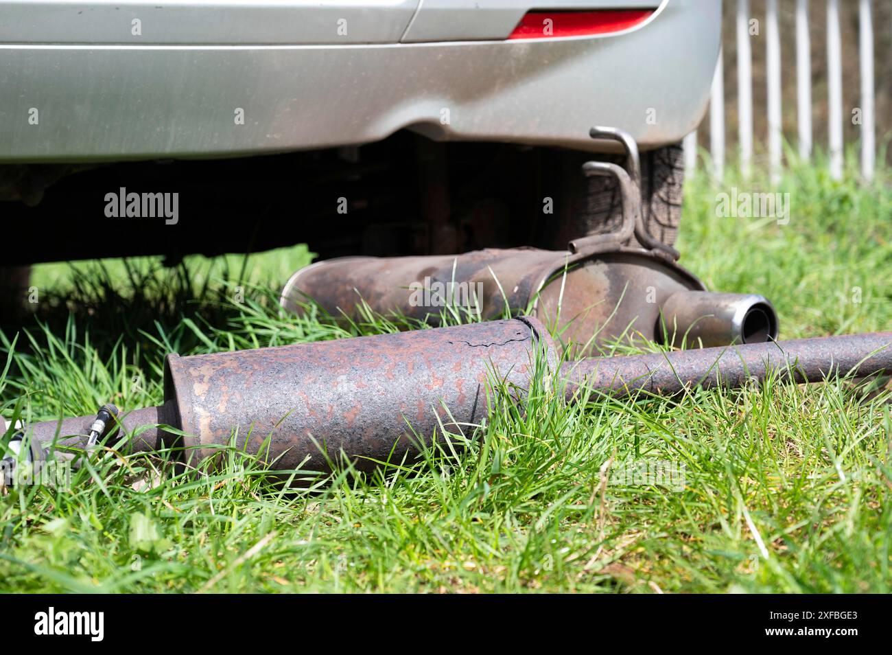 Broken exhaust and muffler of a car, rusted silencer fallen down on the ...