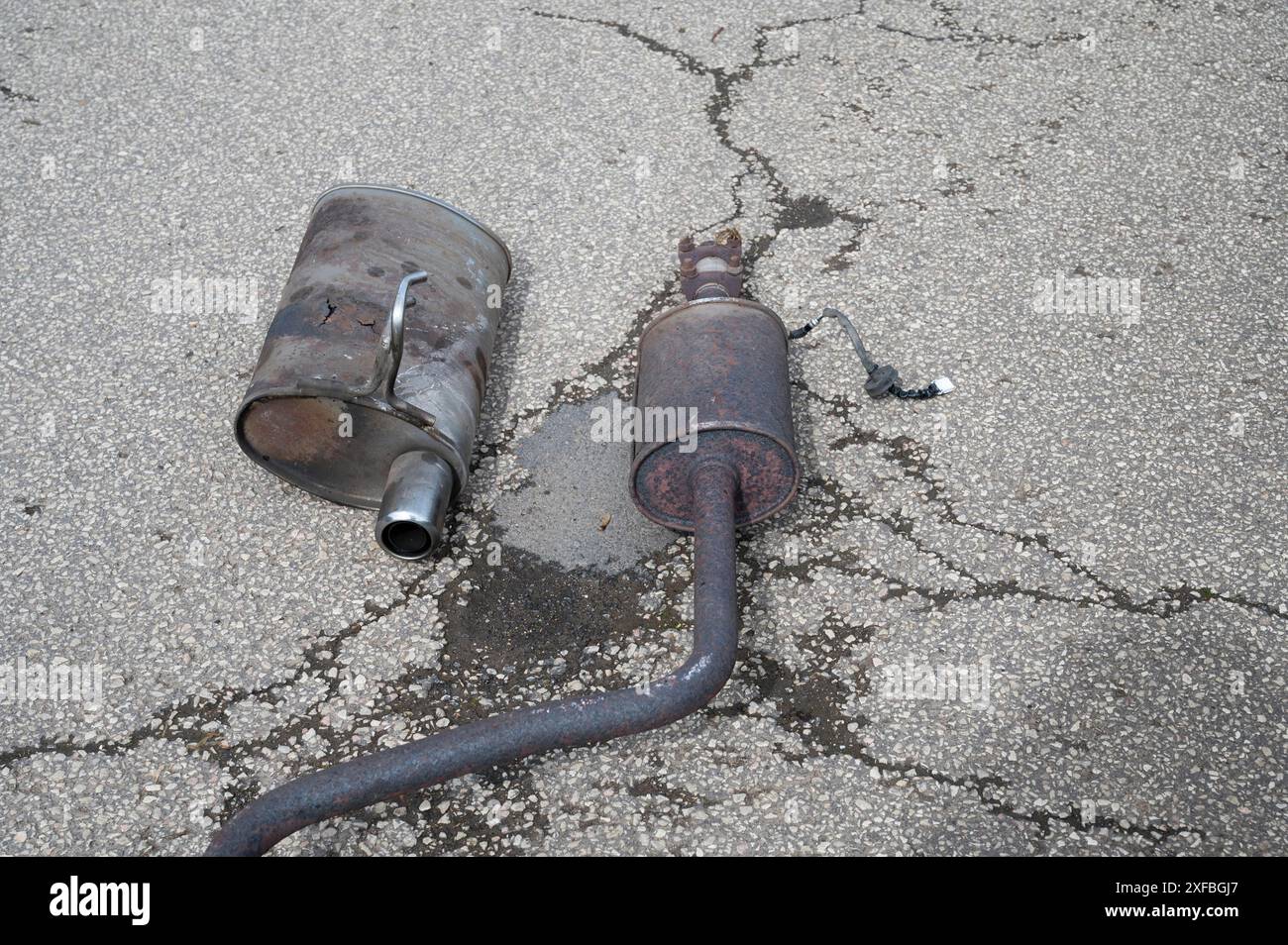 Broken exhaust and muffler of a car, rusted silencer fallen down on the ...
