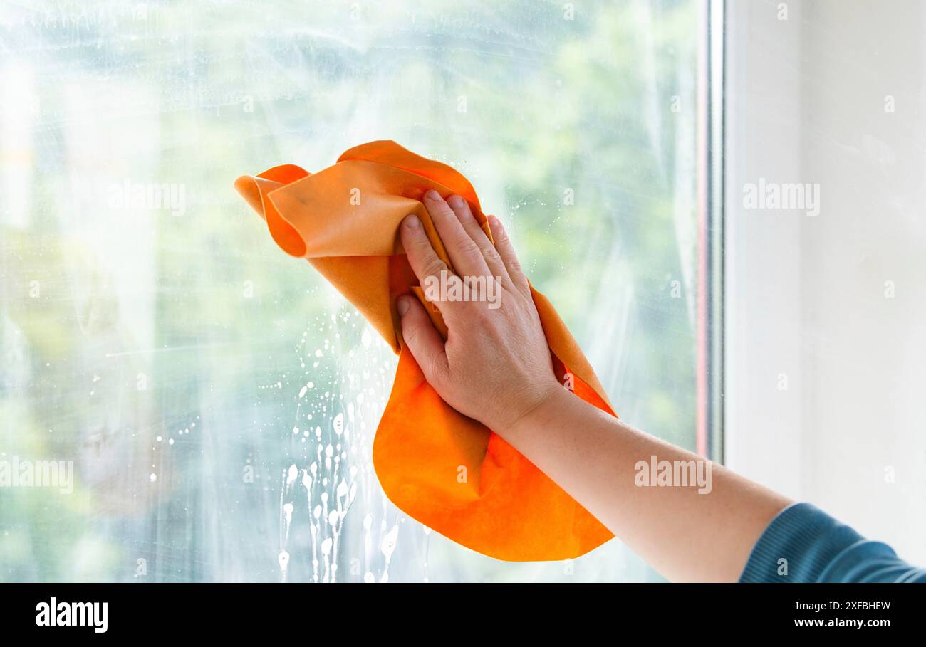 Employee cleaning window pane, wipe with a cloth, dry the water and ...