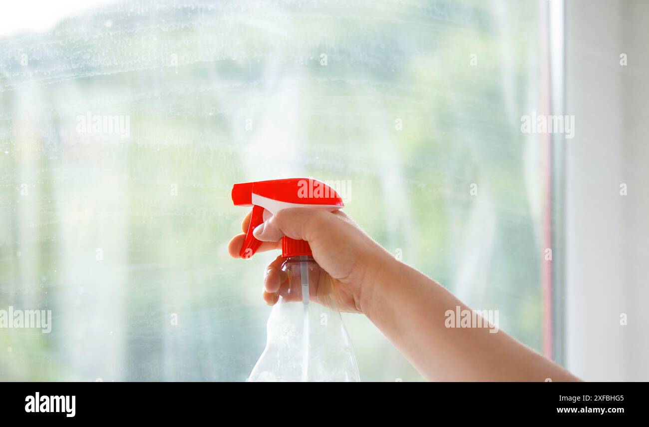 Employee cleaning window pane, spray water and soap, swab dusty and ...