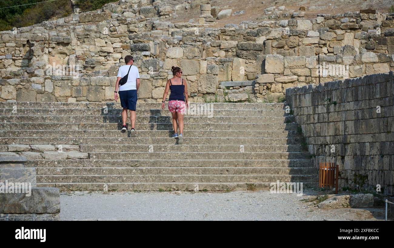 Couple walking up a stone staircase in an ancient ruins site, Kamiros ...