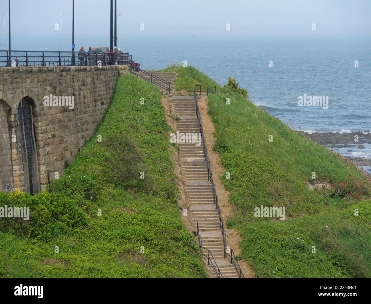 Stone steps leading down the hill to the coast, flanked by a railing ...