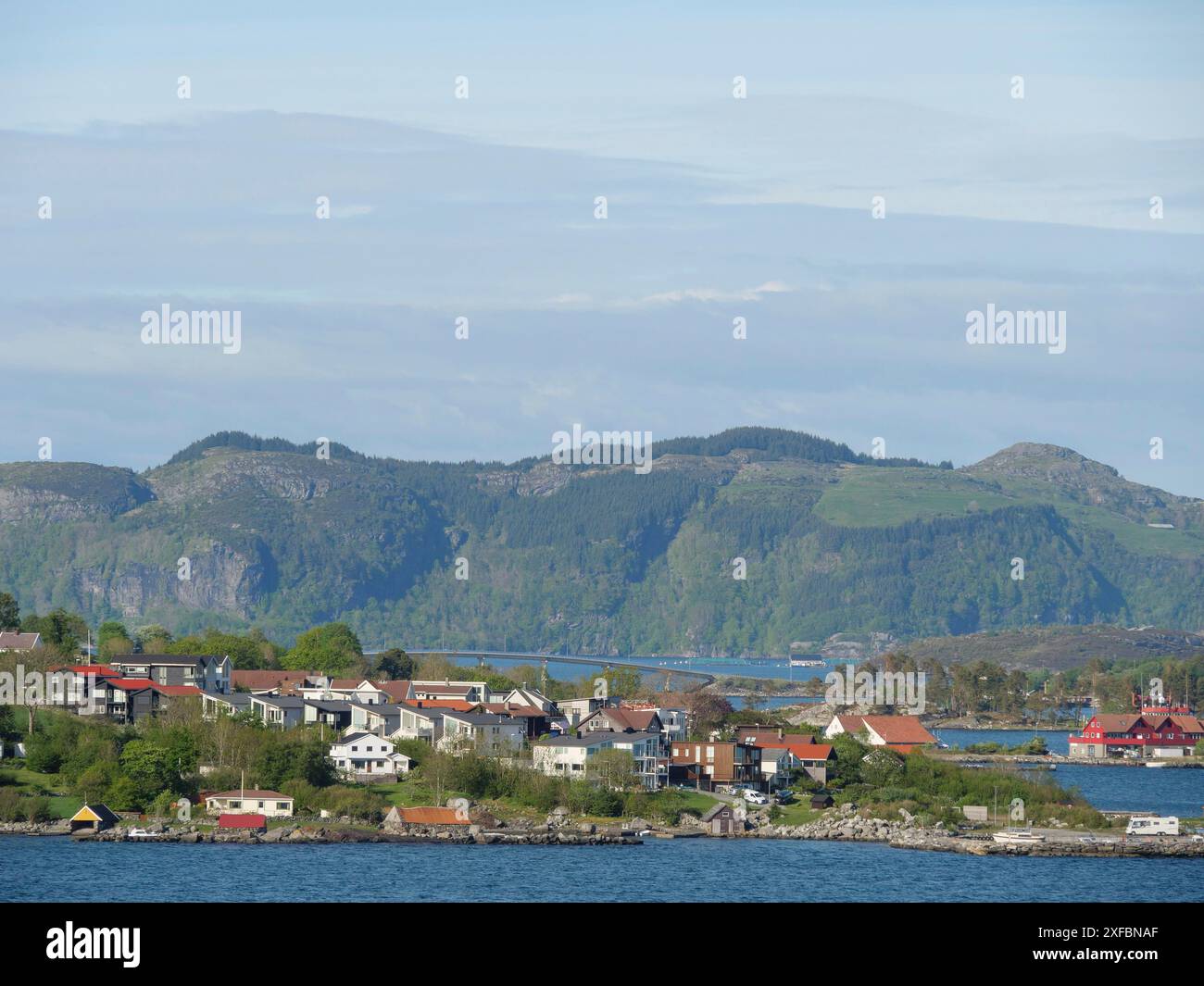 Village by the sea with mountains in the background, peaceful scene ...