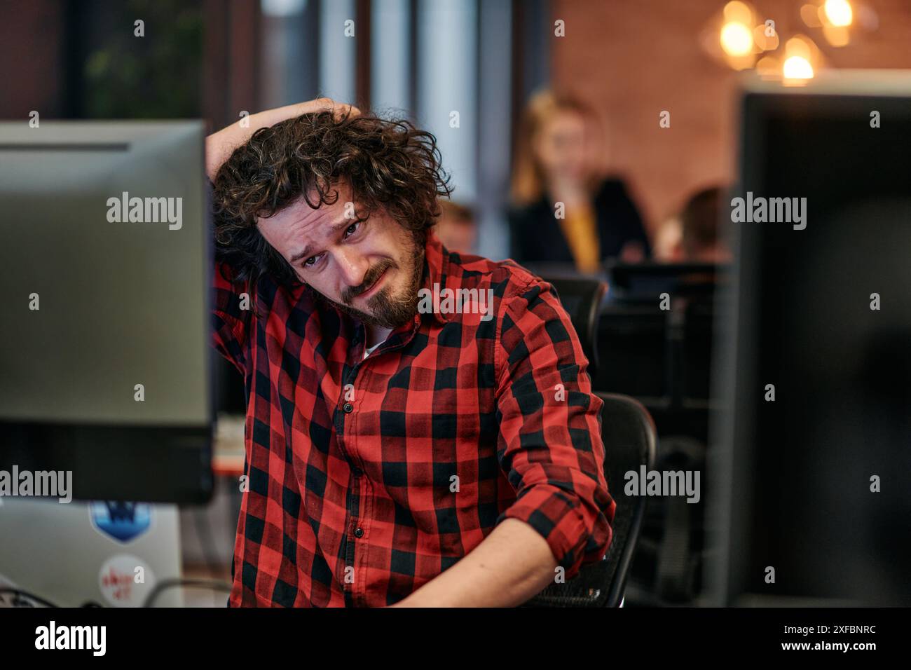 Disappointed Programmer with Messy Hair Looking at Computer Monitor in ...