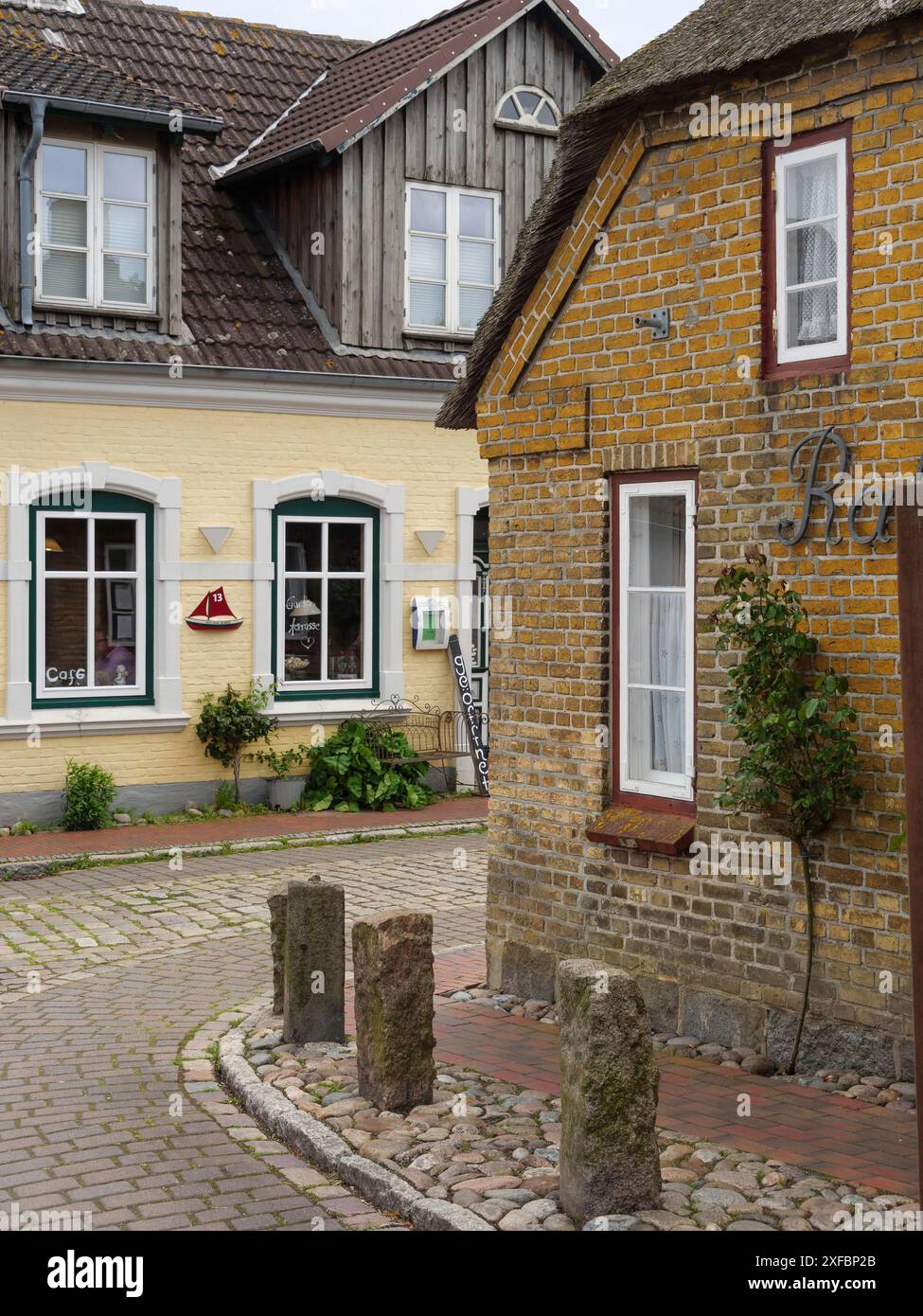 Traditional brick houses with cobblestones and streetlights, surrounded ...