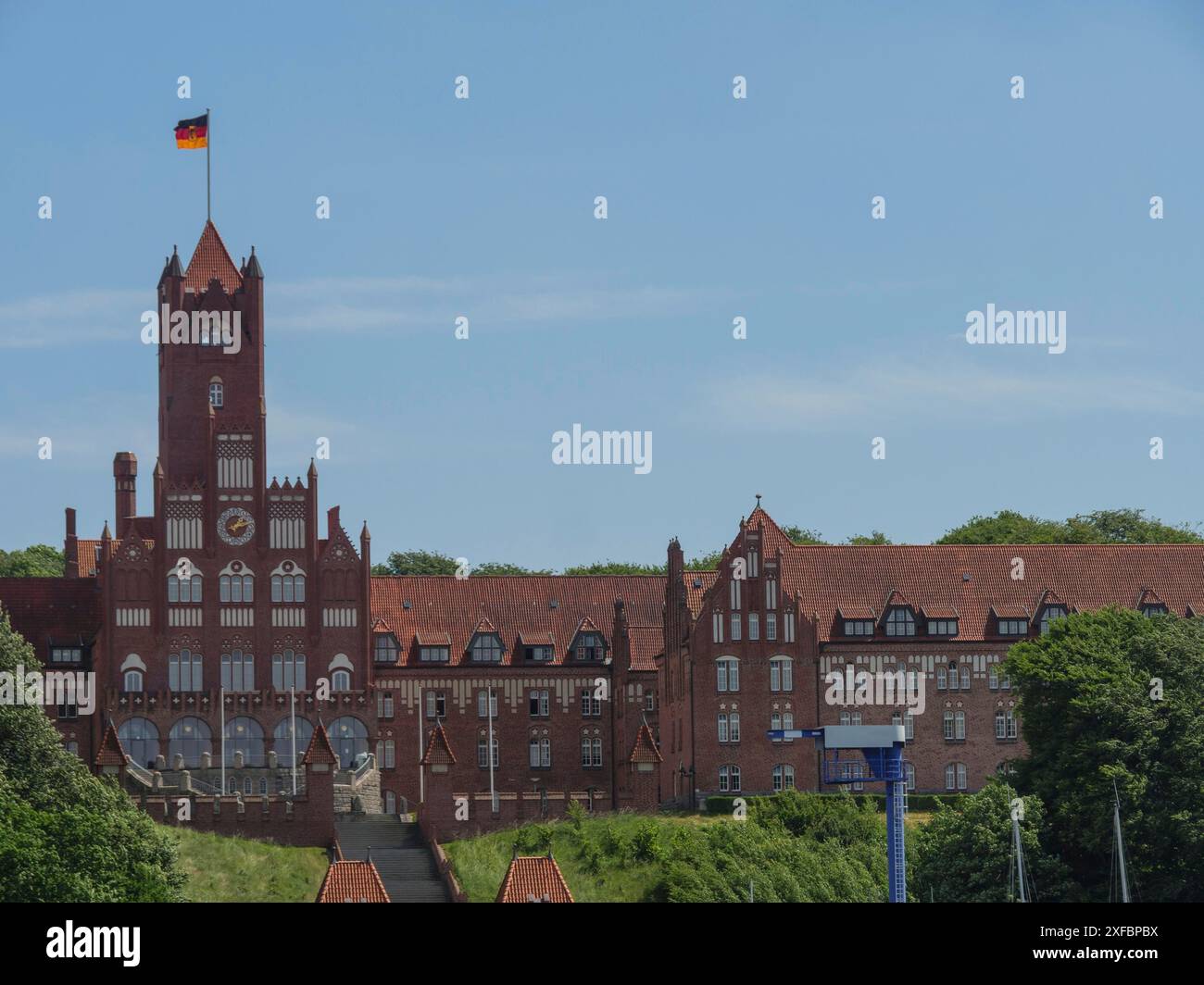 Large brick building with a German flag on top of the tower, surrounded ...