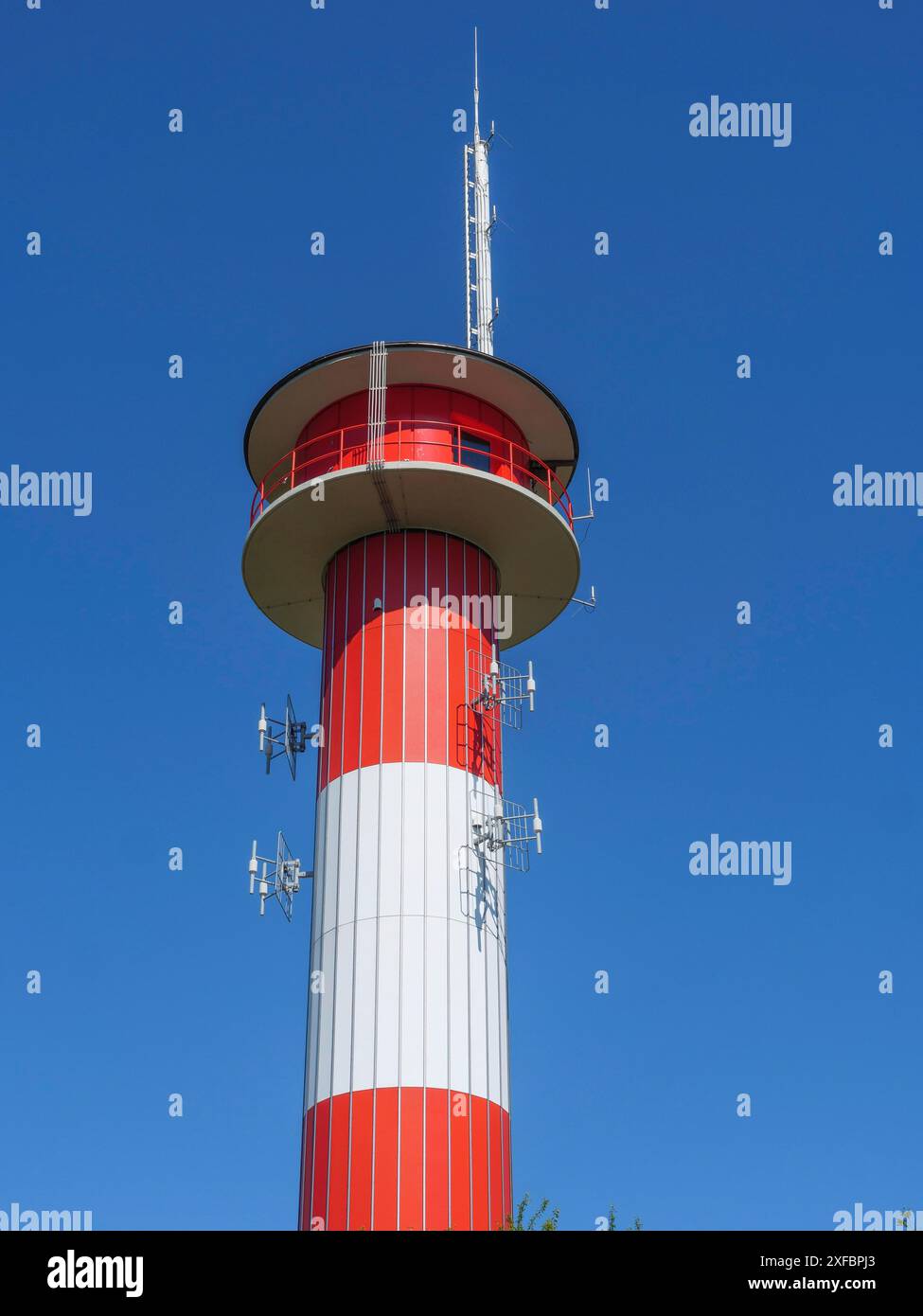 Red and white lighthouse with antennas and clear blue sky, Flesnburg ...