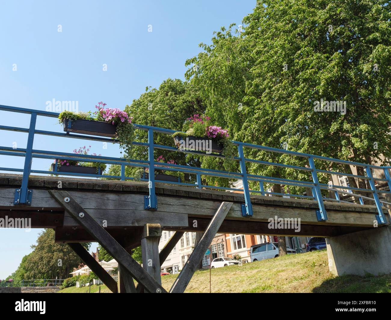 A bridge with flower boxes full of colourful flowers, flanked by a ...