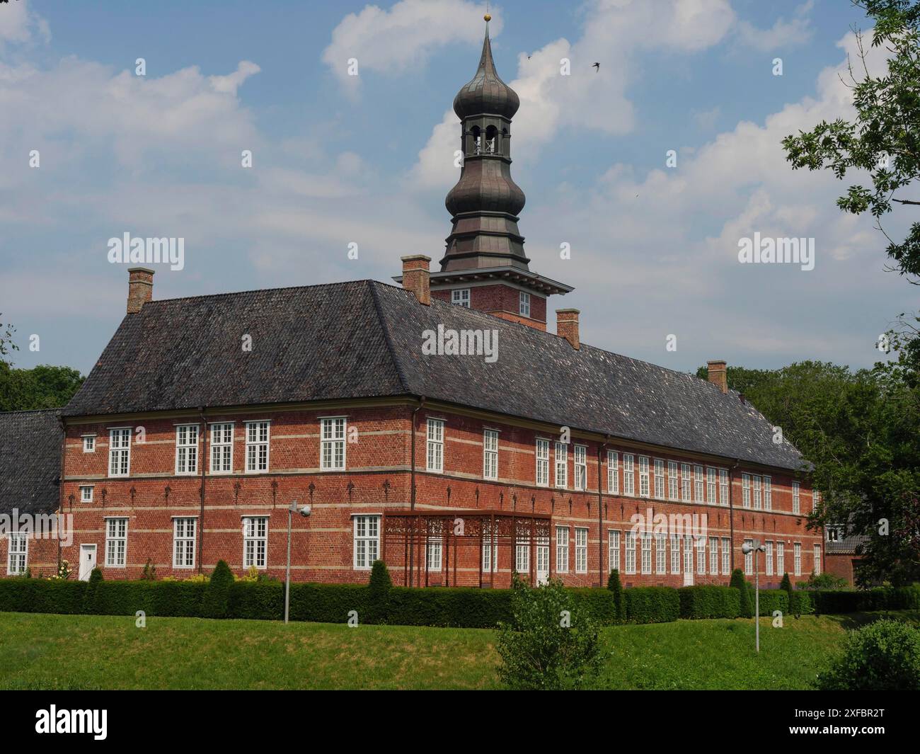 The photo shows a historic brick building with a church tower under a ...