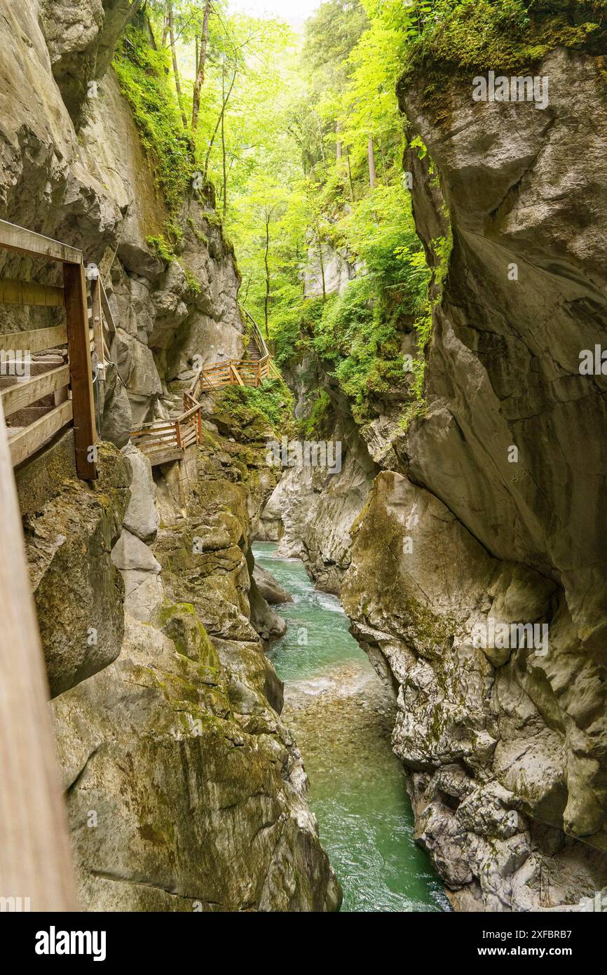 Narrow valley with steep rock faces, through which an emerald green ...
