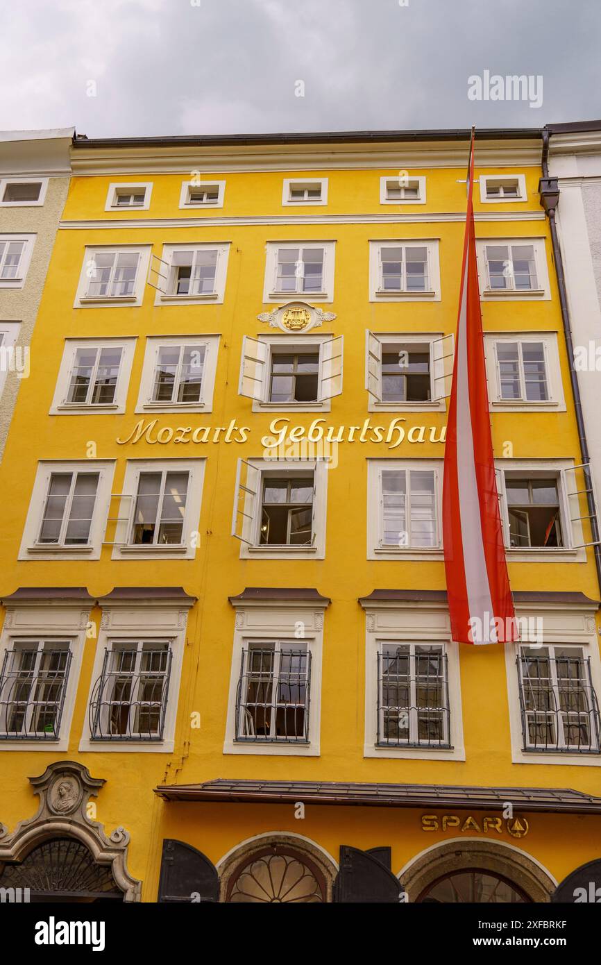Mozart's birthplace, a striking yellow building with a flag and open ...