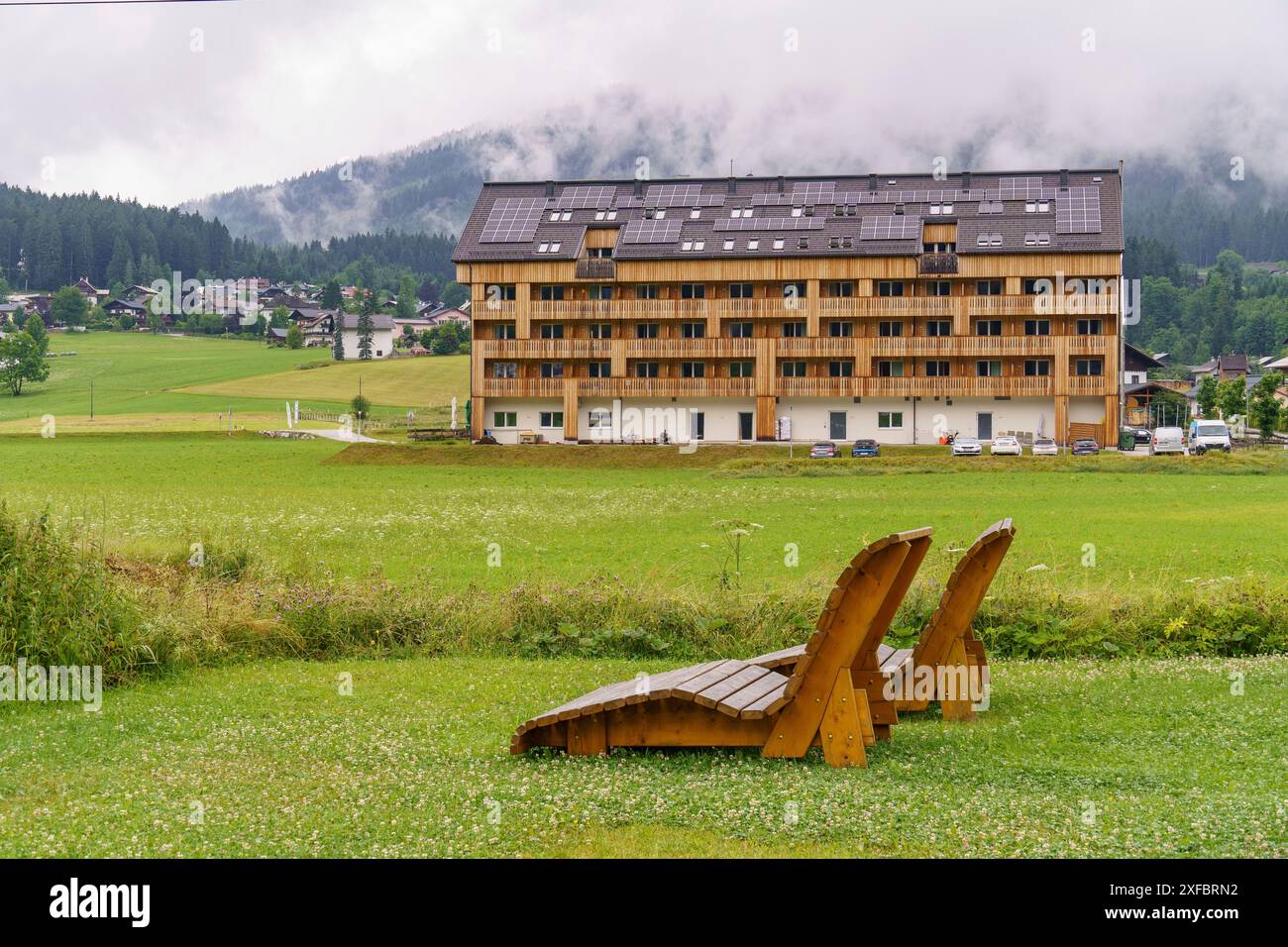 Large hotel building in a green setting with mountains and meadows ...