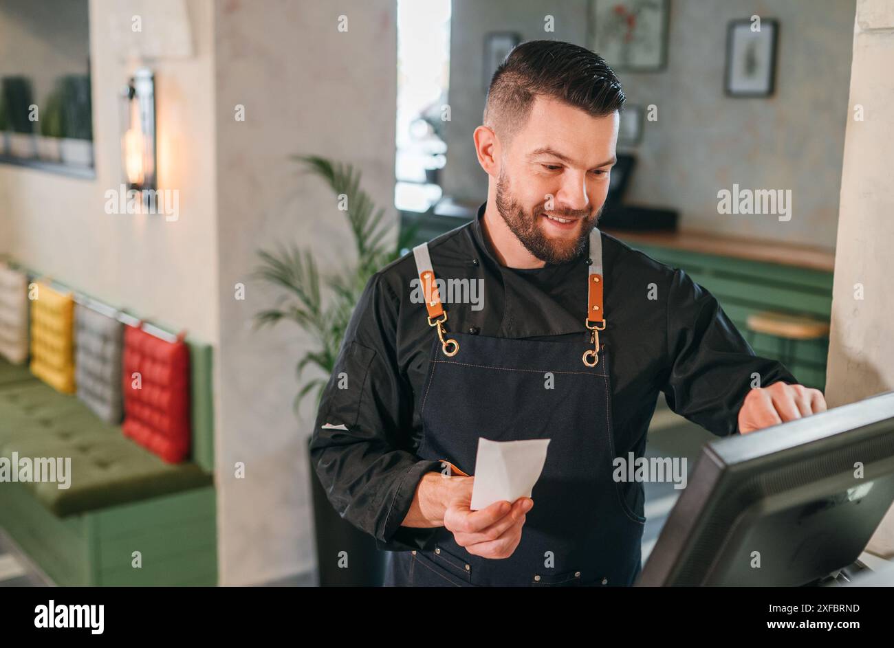 Stylish bearded smiling waiter dressed black uniform processing ...