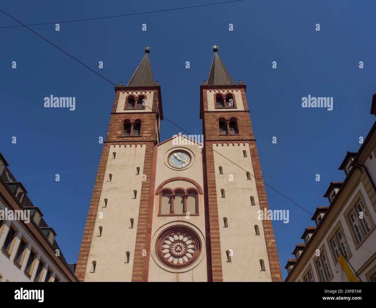 Double bell towers of a gothic church with clock in front of a blue sky ...
