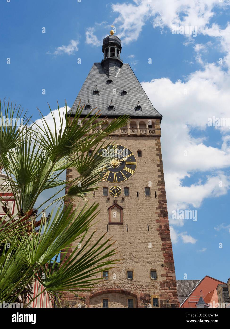 Historic clock tower in gothic style under a blue sky with clouds ...