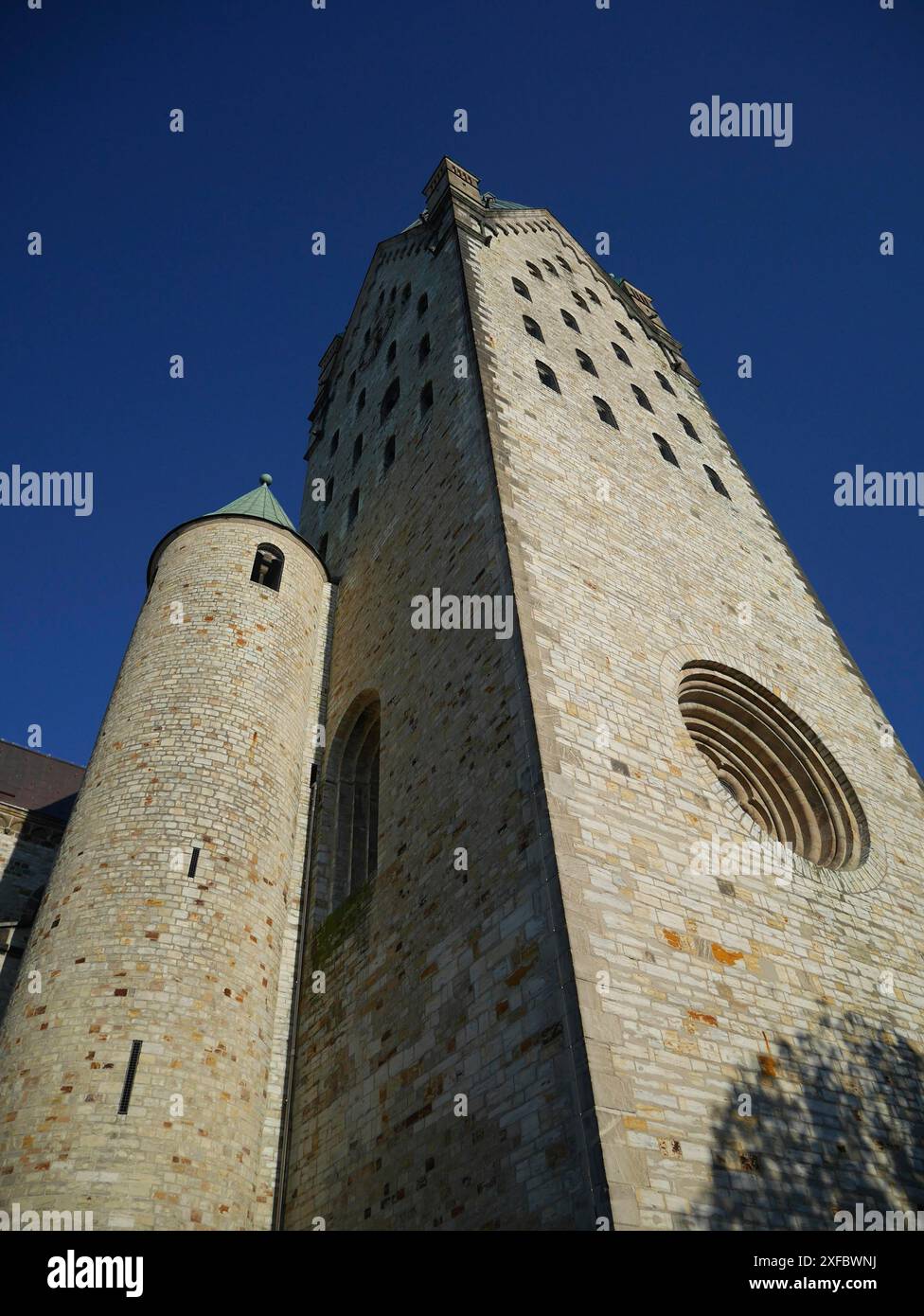 Stone tower of a church rising into the clear blue sky, twin-towered ...