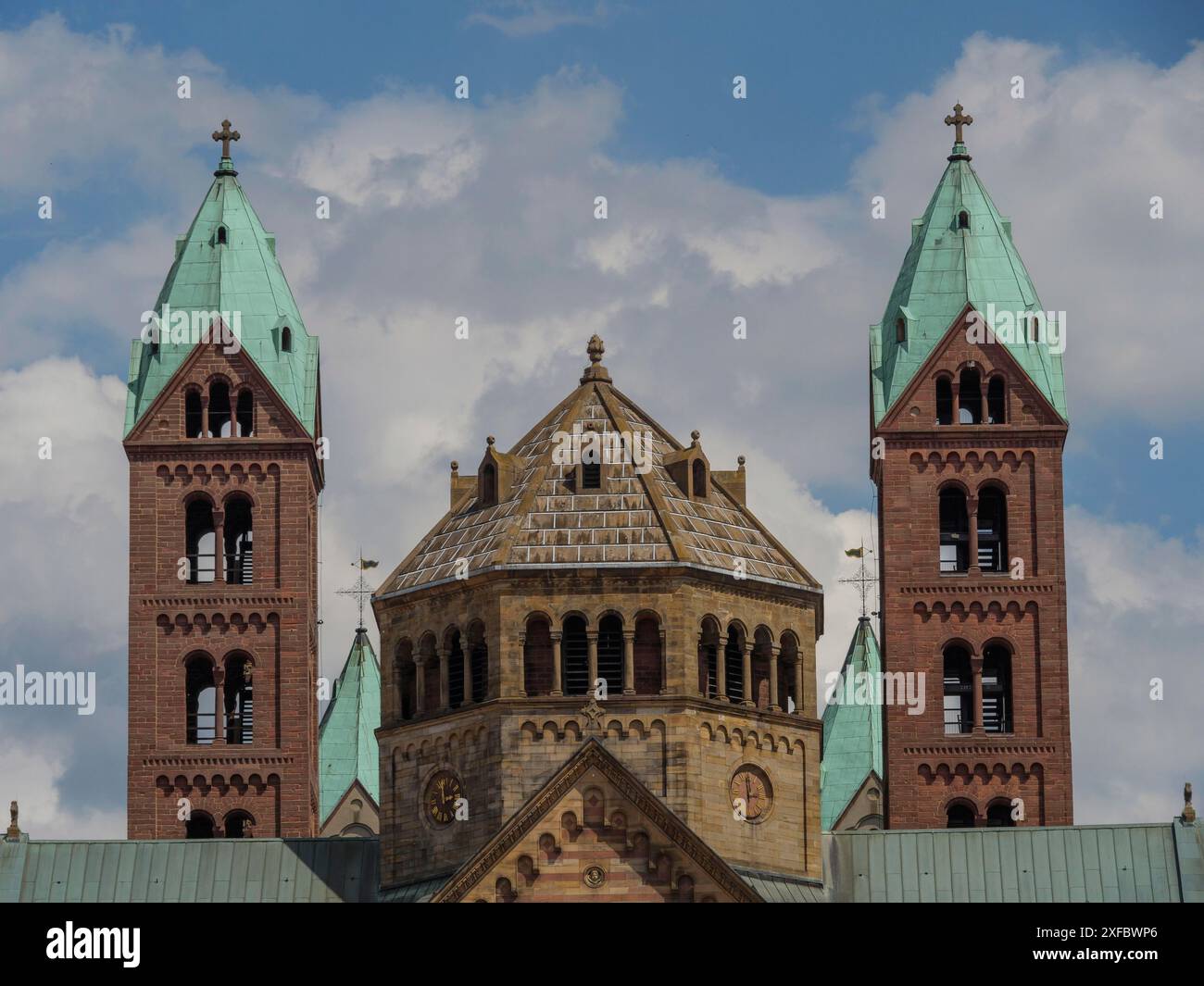 Romanesque brick church towers in front of a blue sky with passing ...