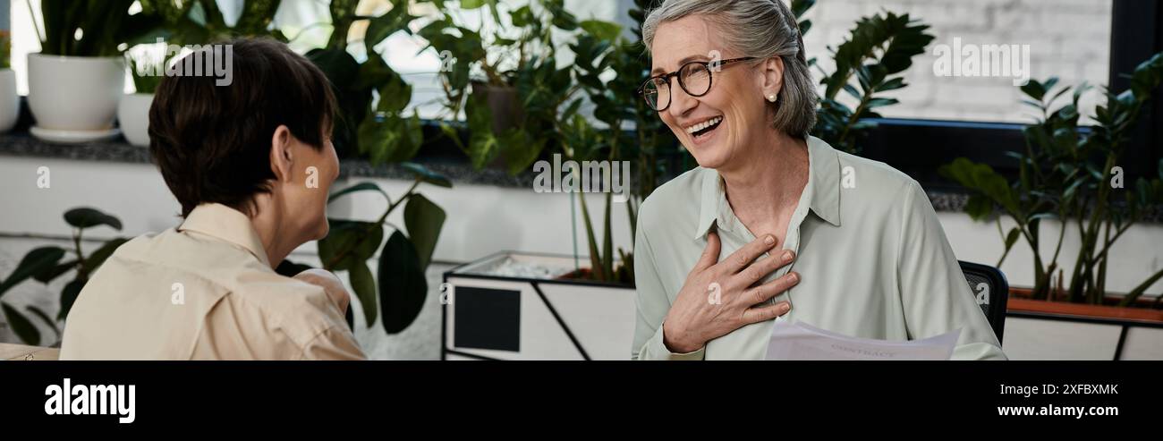Two women engage in conversation inside professional office setting ...