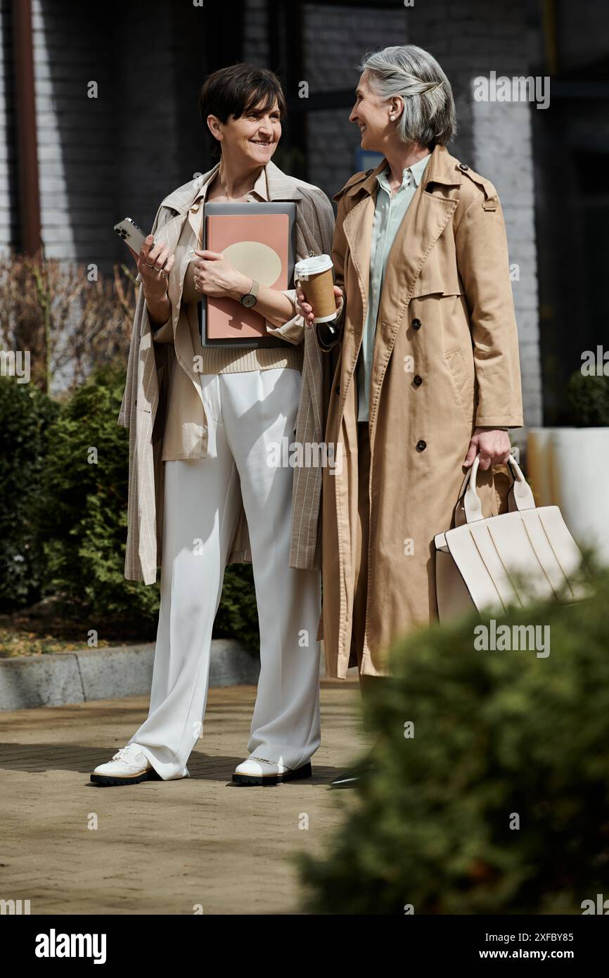 Two women stand side by side Stock Photo - Alamy