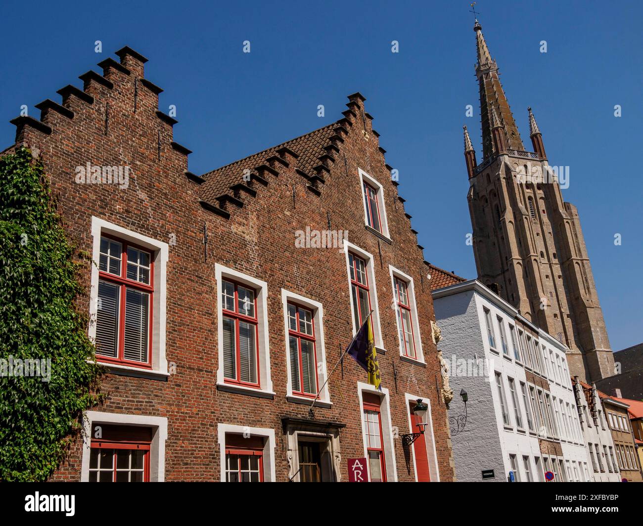 Row of historic buildings with gabled roofs and a Gothic church tower ...