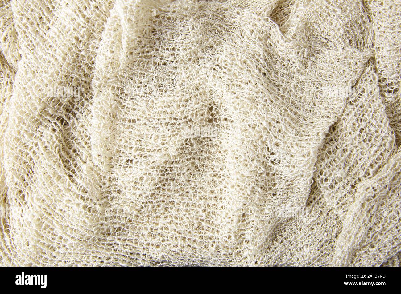 Fabric is made of a fuzzy net-like material, beige color, which gives ...