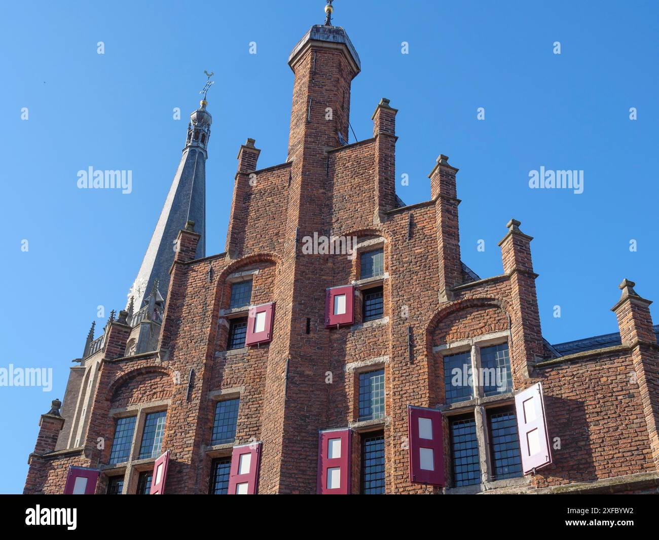 Tall historic buildings made of red bricks and a church tower under a ...