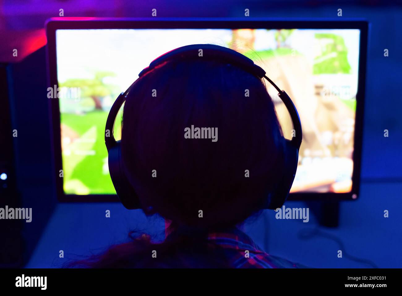 Person Wearing Headphones and Playing a Video Game on Computer Stock ...