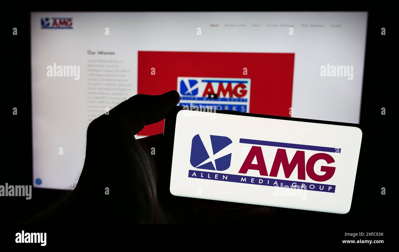 Person holding mobile phone with logo of American broadcasting company ...