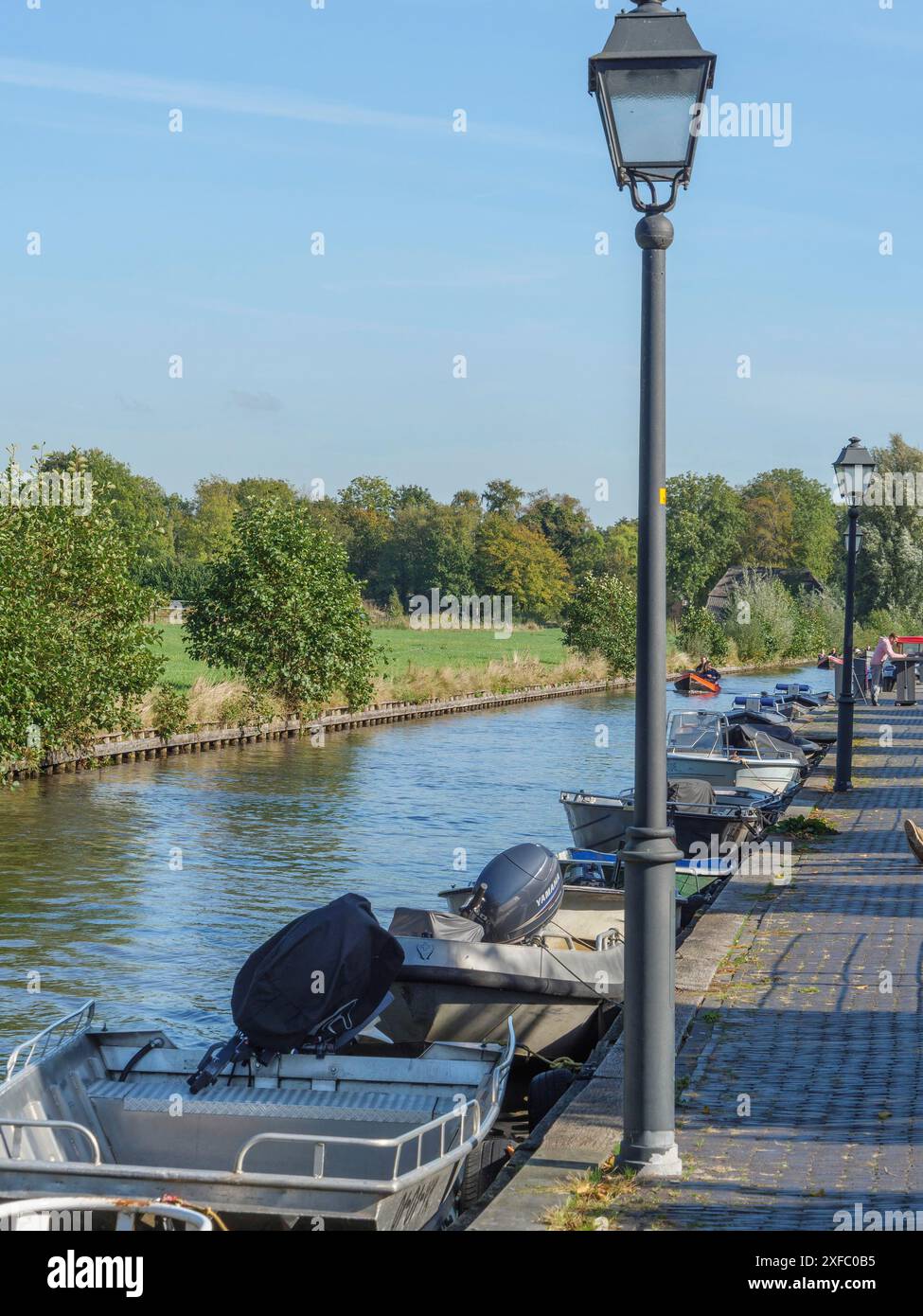 Boats along a cobbled path on the canal bank, lanterns and green ...