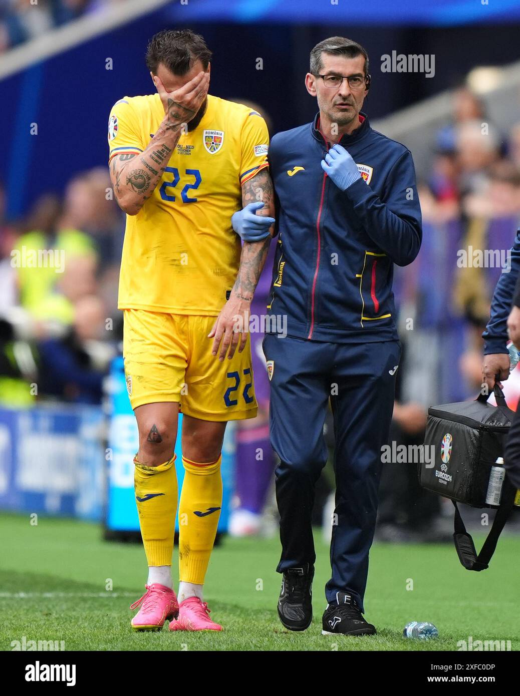 Romania's Vasile Mogos leaves the pitch after picking up an injury ...