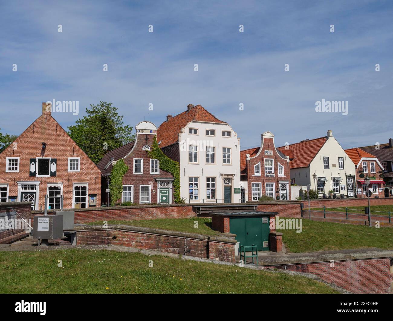 Historic houses with red and white brick facades under a blue sky in an ...