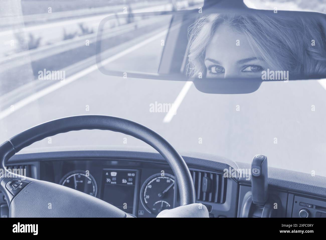 Reflection of woman's face in rear view mirror while driving truck ...