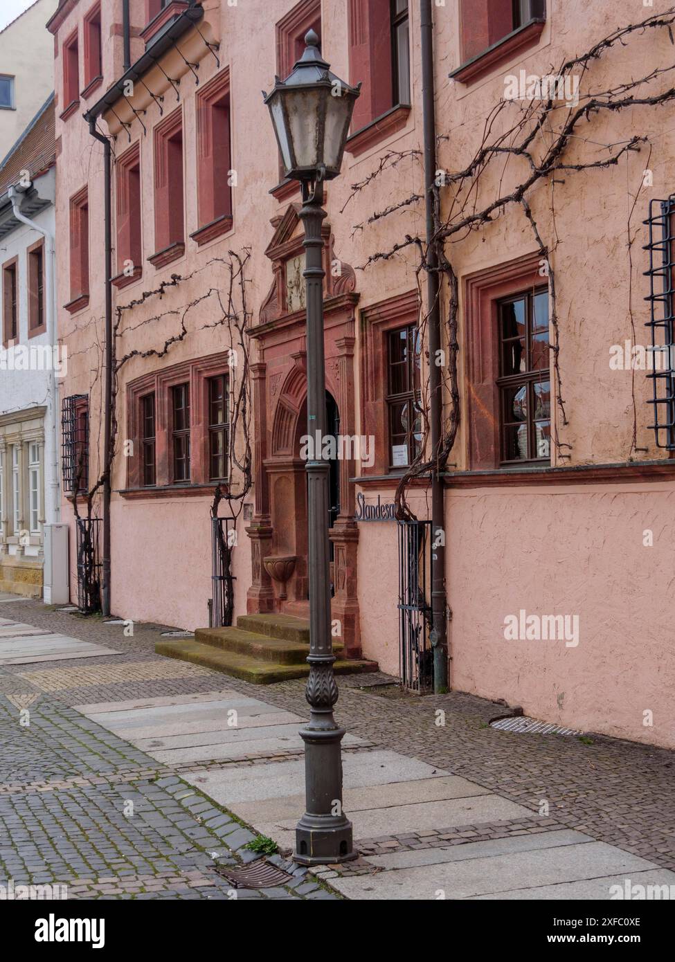 Historic street scene with an old lantern and buildings with red window ...
