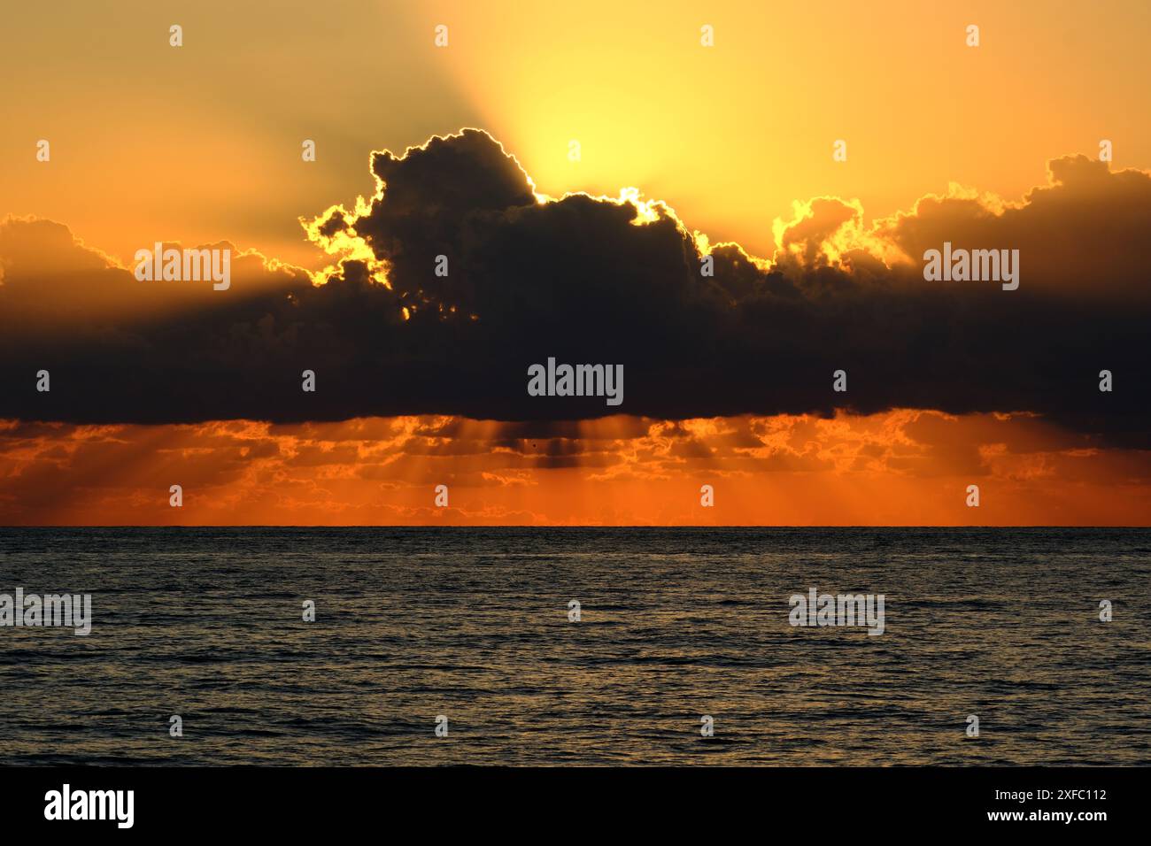 Sunset over the sea with clouds and rays of light on the horizon Stock ...
