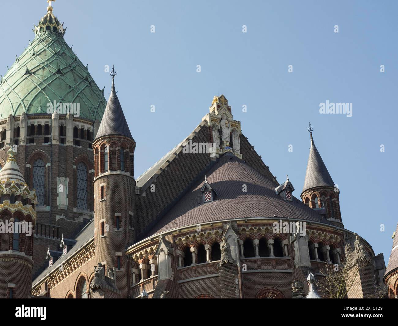 Spire of a gothic church with green roof and several pointed towers in ...