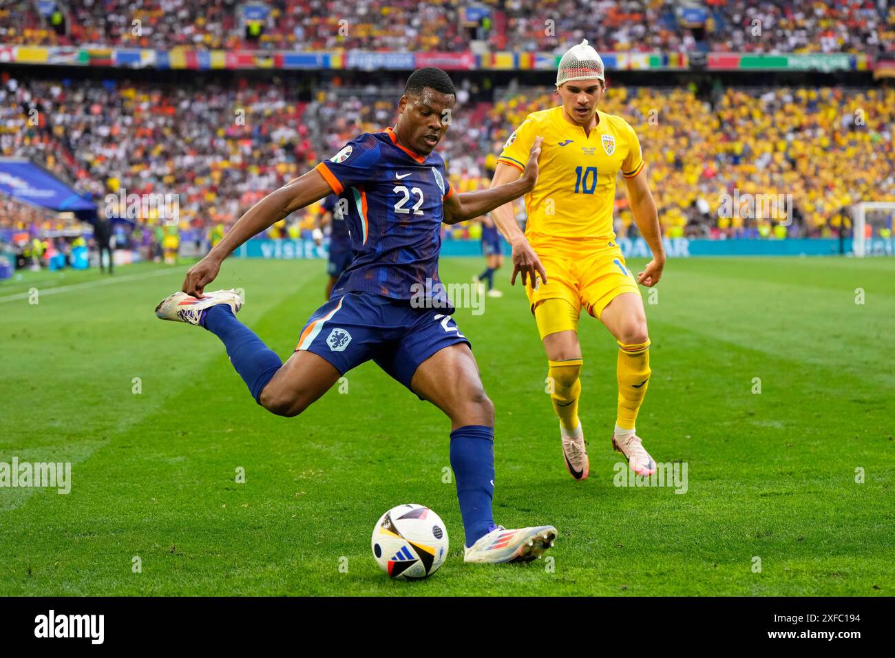 Denzel Dumfries of the Netherlands crosses the ball in front of Romania ...
