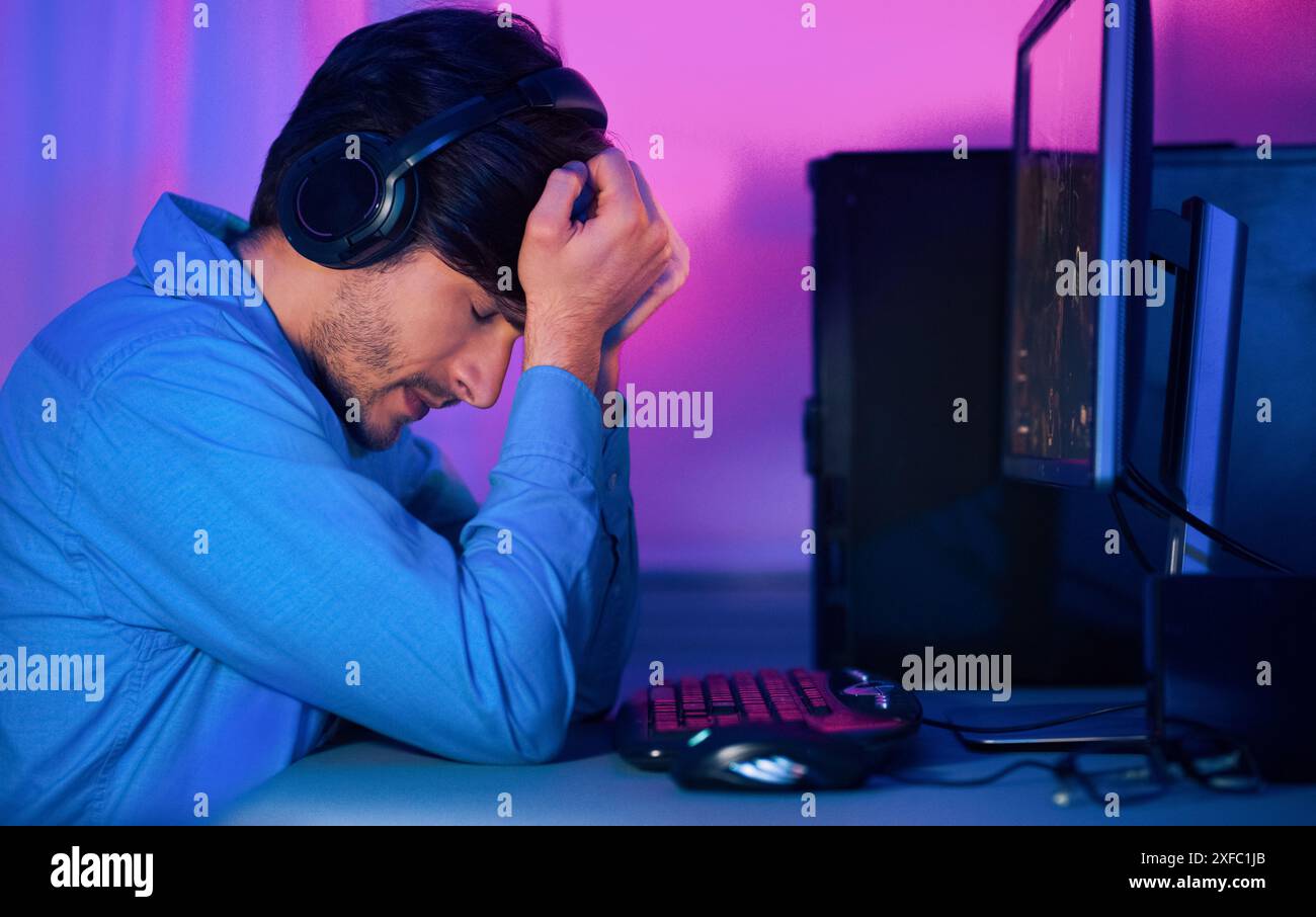 Frustrated Gamer With Headphones In A Dimly Lit Room Stock Photo - Alamy