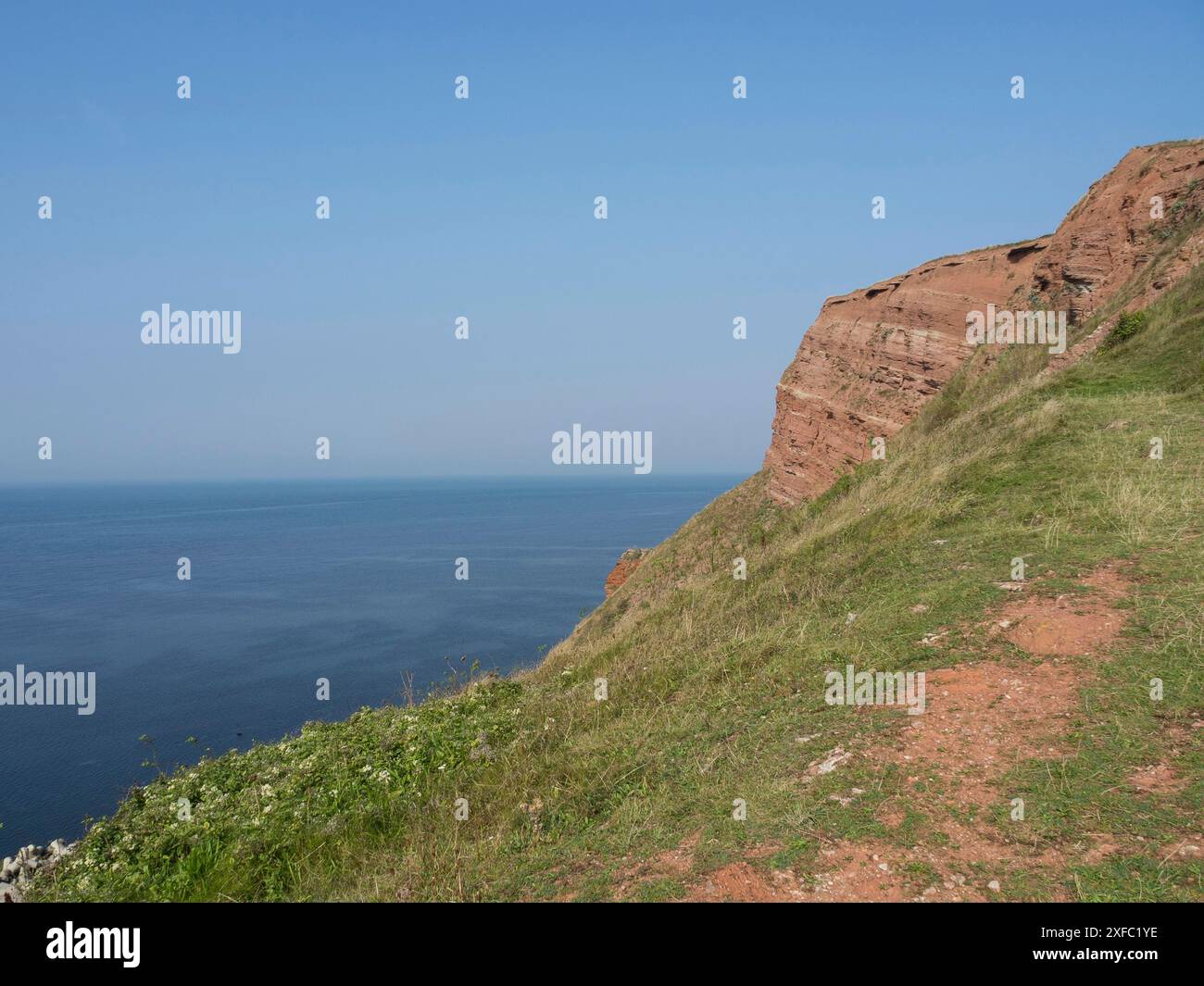 Red cliff towers over the blue sea under a clear sky, helgoland, north sea, germany Stock Photo ...