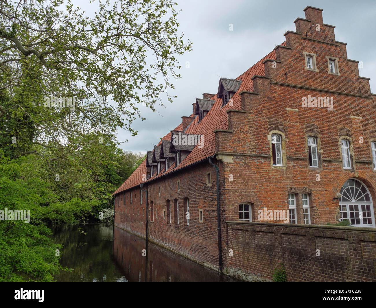 Medieval brick warehouse with gable wall, adjacent to a moat ...