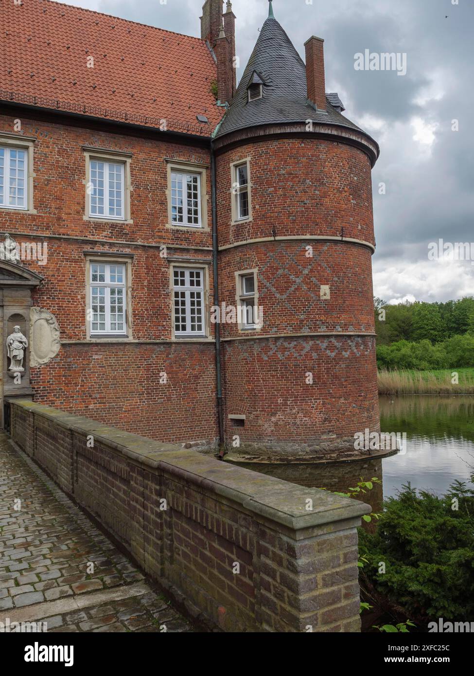 Brick castle with tower and battlemented roof, adjacent to a moat ...