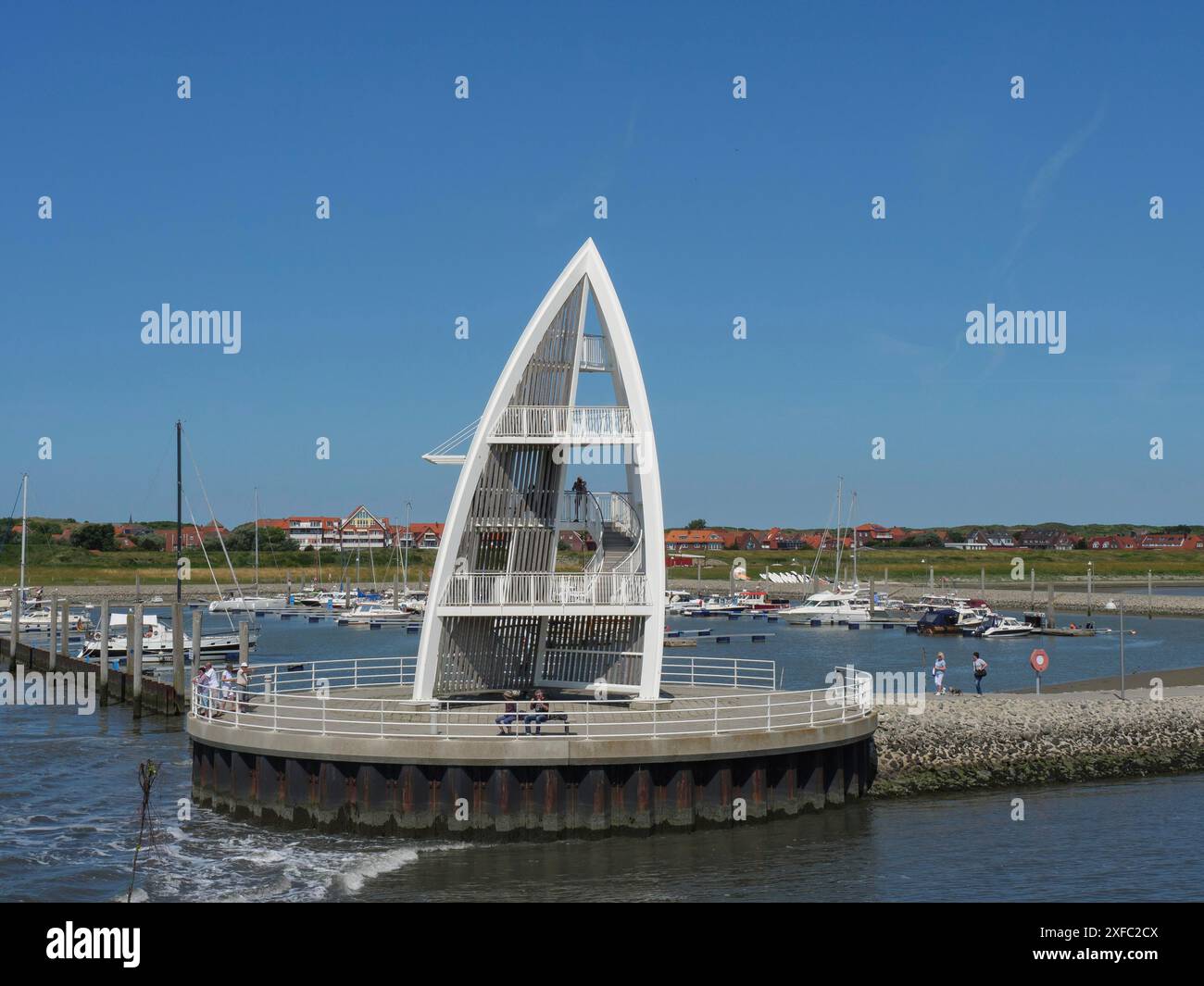 Modern, sail-shaped tower building at the harbour with clear blue sky ...