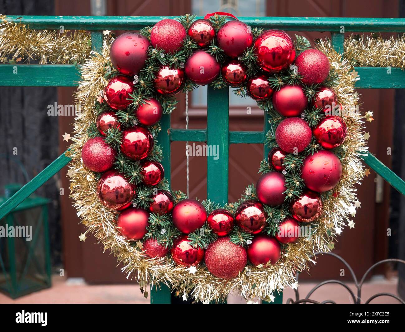 Christmas decorated wreath with red baubles and fir branches on a door ...