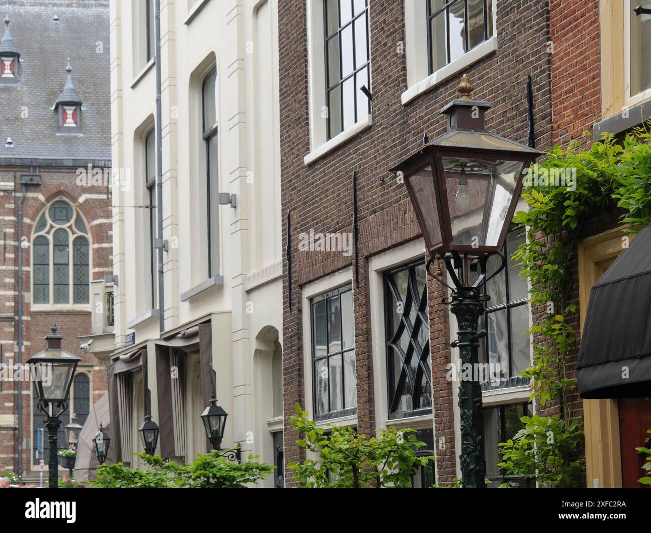 Row of urban buildings with traditional alleyway lamps in a narrow ...