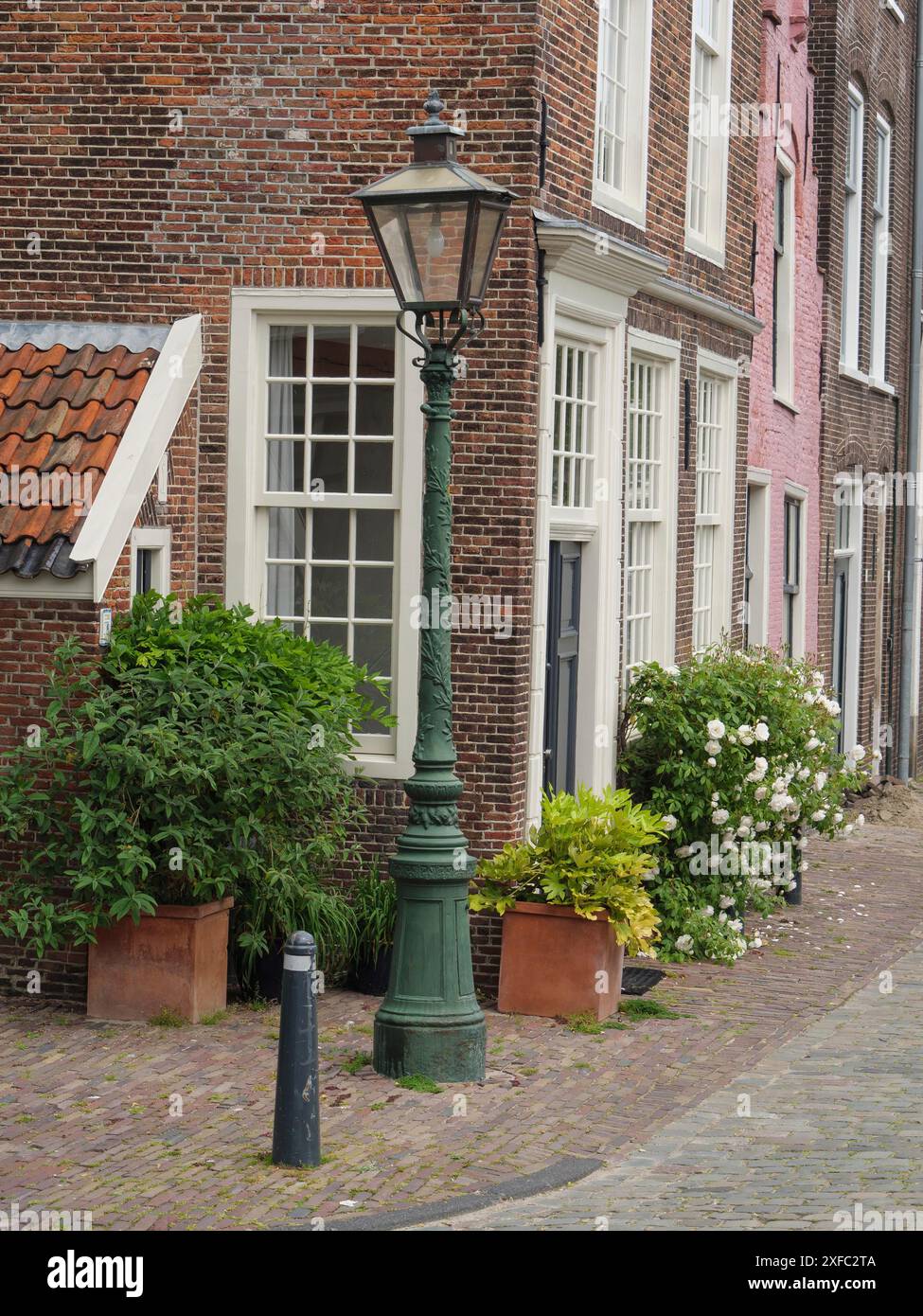 Street corner in an old town centre with brick houses, lamp and flowers ...
