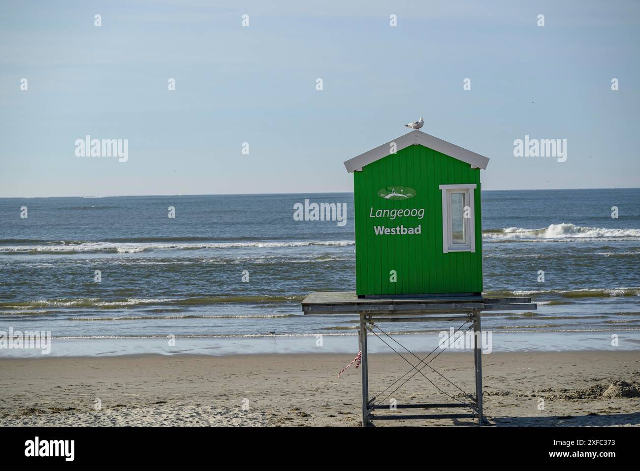 Green hut on the beach with a view of the sea and waves under a bright ...